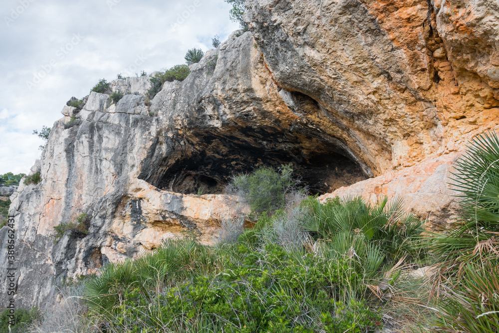 Beautiful natural cave on a cliff. Prehistoric excavation. Neanderthal ...