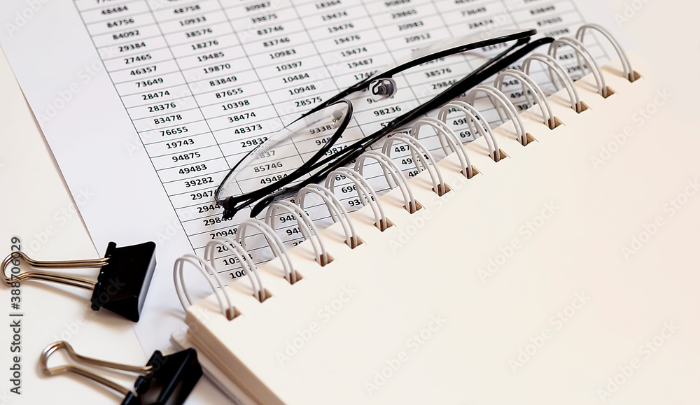 Office Desk with financial papers, charts,notepad and glasses. Empty ...