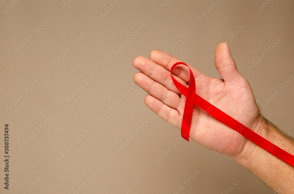 Top view of mans hand who holding red ribbon as a solidarity with ...