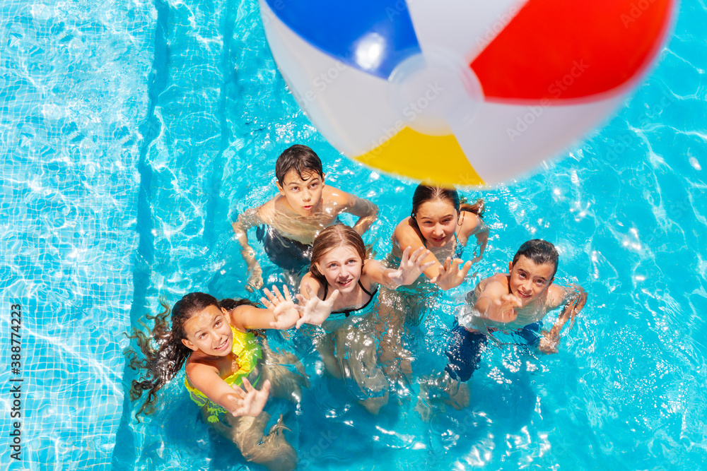 Many kids in swimming pool play with inflatable ball view from above ...
