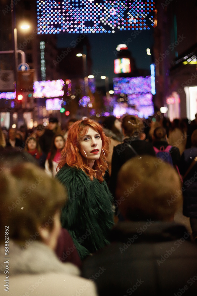 mujer mirando a cámara en medio d ela multitud de la ciudad con luces de navidad al fondo Stock ...