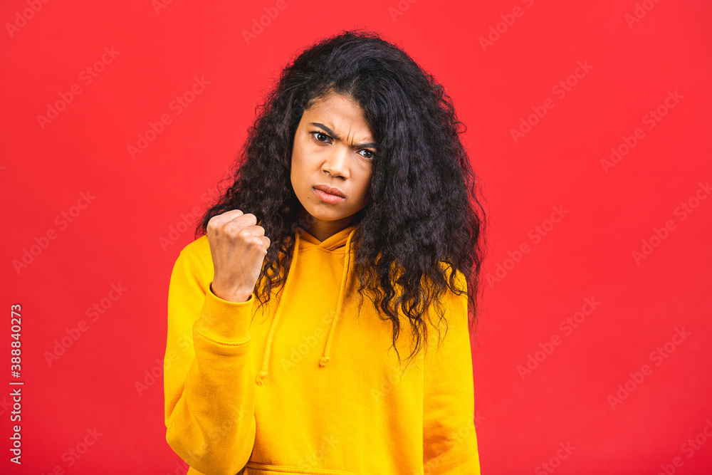 Angry brave African young woman isolated over red background raising ...