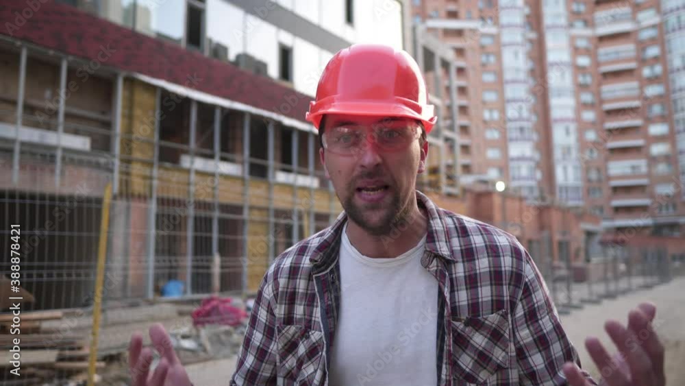 Young caucasian angry construction worker shouting at construction site ...