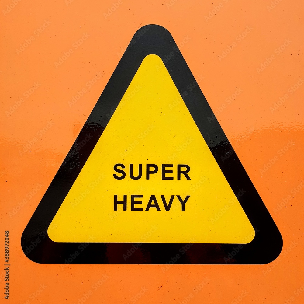 A yellow warning sign informing of a super heavy weight limit on ...