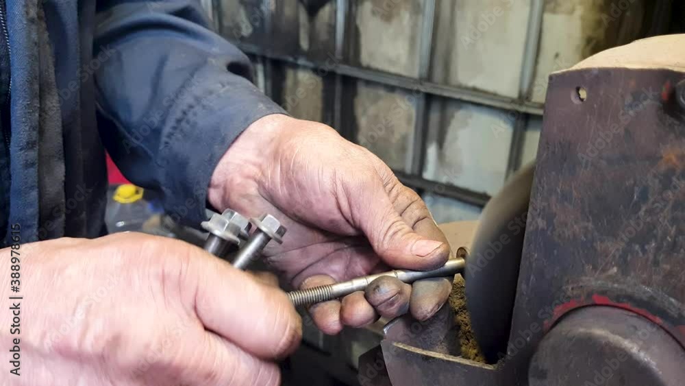The process of turning a bolt turner at a car repair station. The weary ...