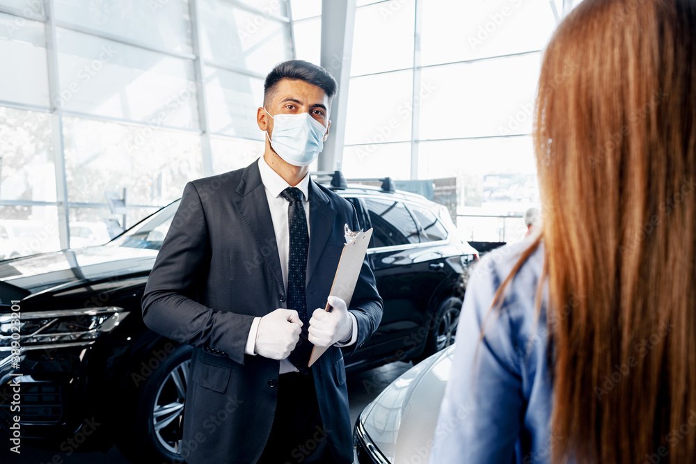 Man car salesman in face mask talking to a client in showroom Stock ...