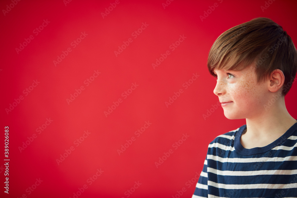 Profile Of Smiling Young Boy Against Red Studio Background Stock Photo ...