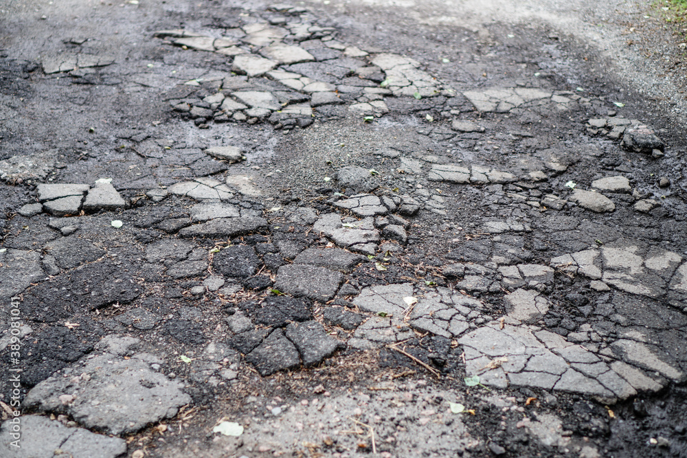 Destroyed road in poor condition requiring repair. Holes in the asphalt ...