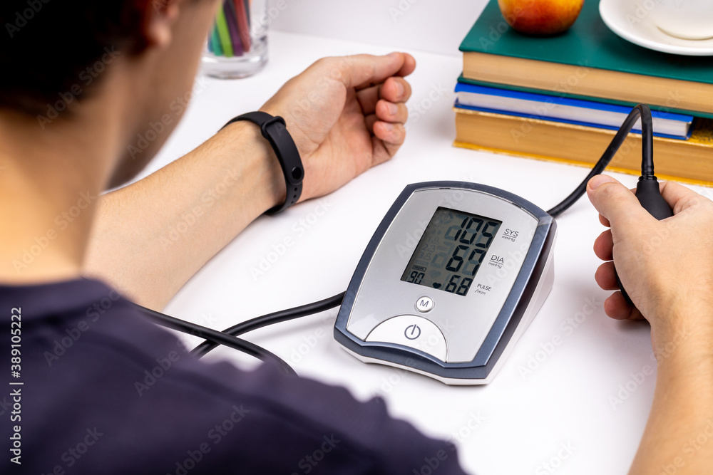 30 years old male person check his blood pressure at home. medical ...