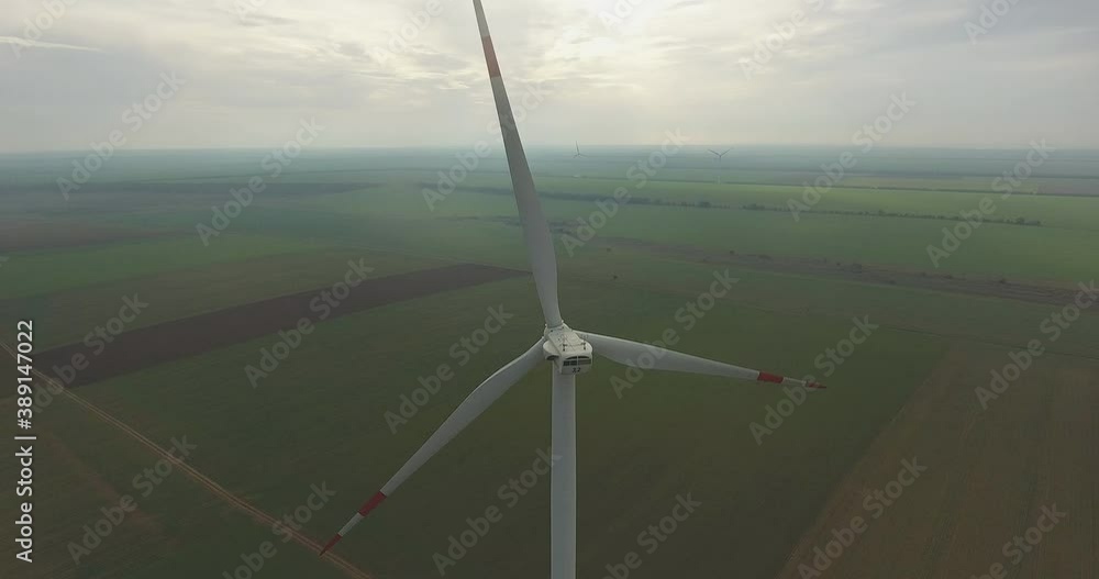 Fly over the drone around windmill. Wind generator with slowly rotating blades against ...