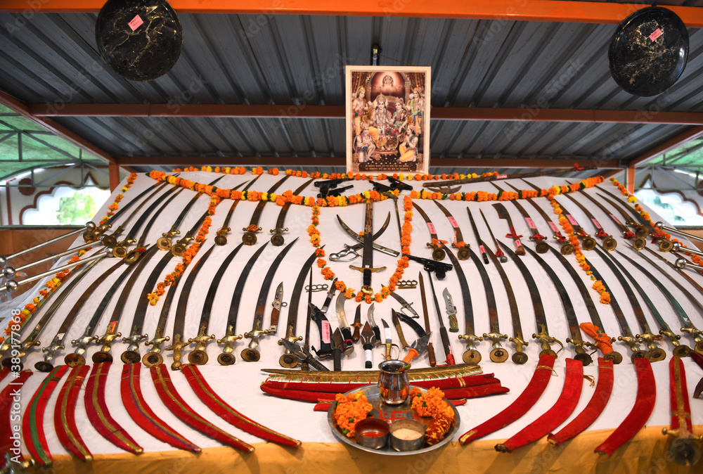 Arms placed in front of Lord Rama's picture during Shastra Puja ...