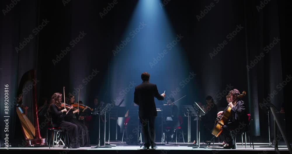 Cinematic close up shot of conductor directing symphony orchestra with ...