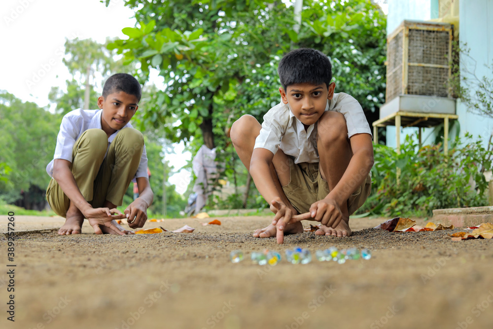 Indian child playing with glass marbles which is an old Indian village ...