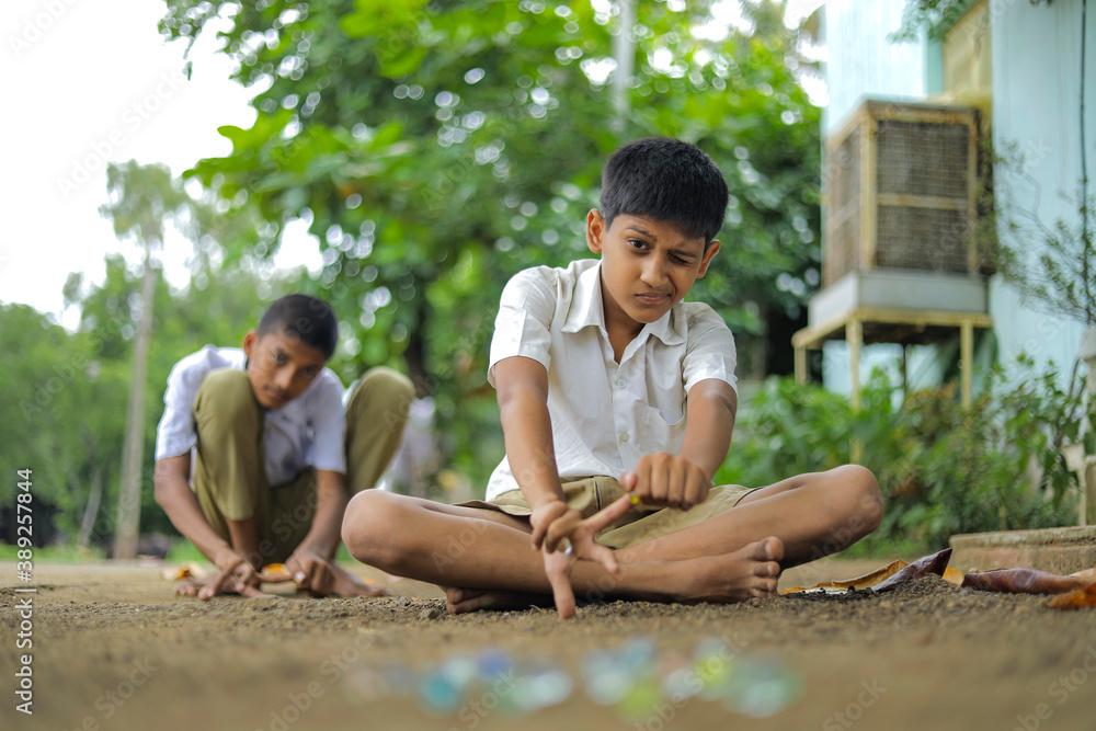 Foto de Indian child playing with glass marbles which is an old Indian ...