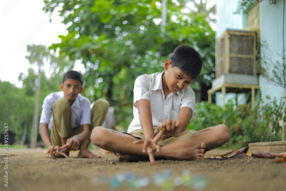 Foto de Indian child playing with glass marbles which is an old Indian ...