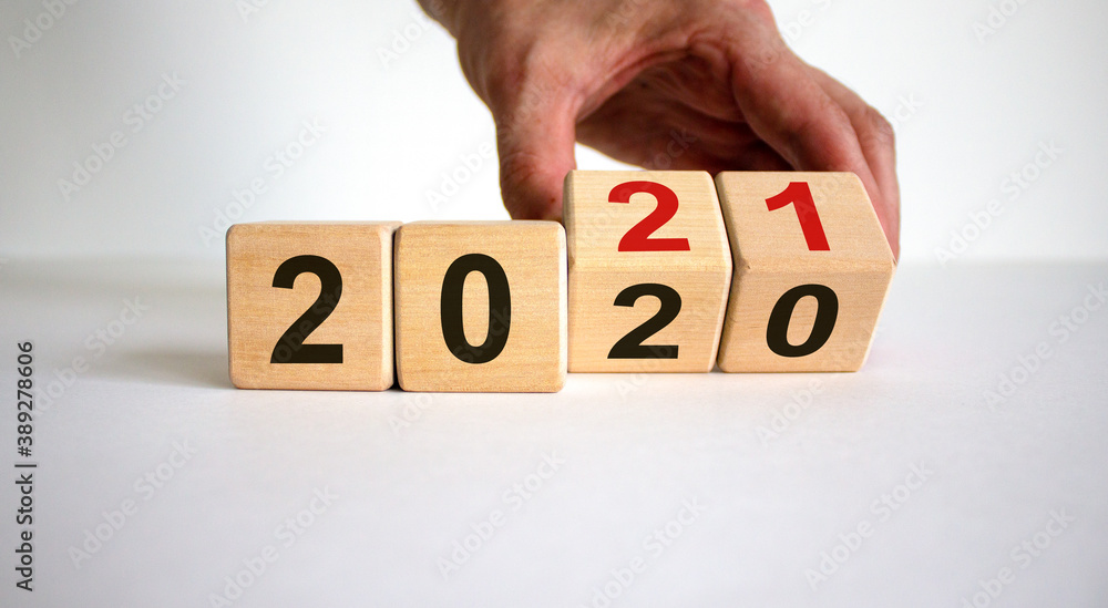 Hand turns cubes and changes the year '2020' to '2021'. Beautiful white ...
