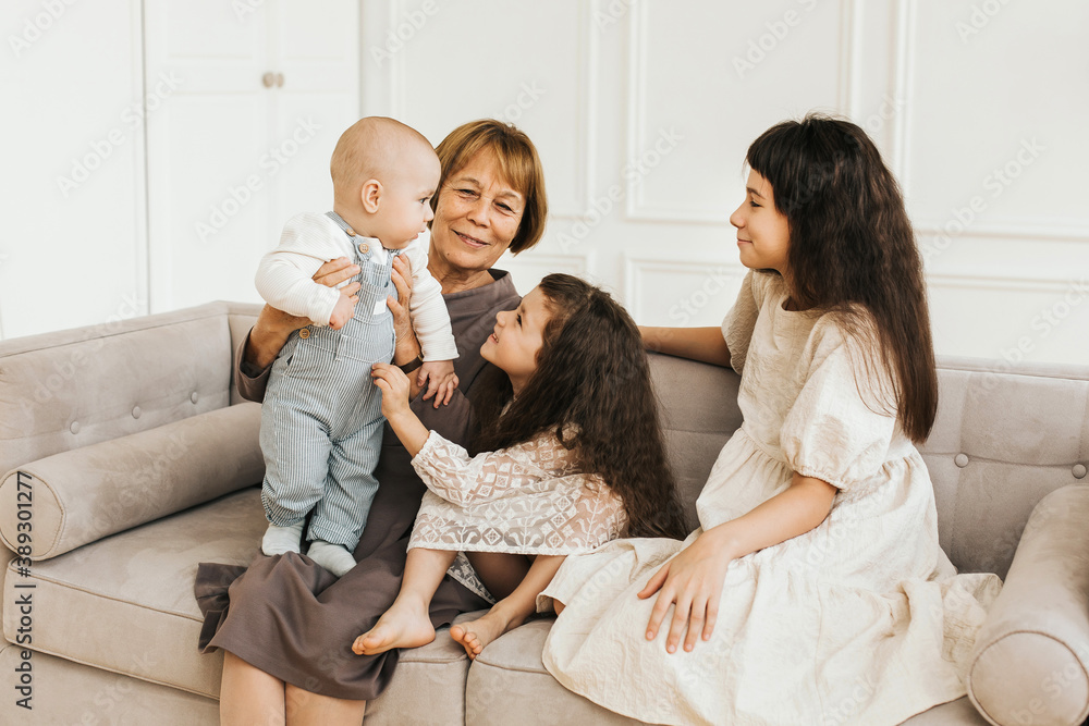 Portrait of a beautiful grandmother and her three grandchildren.Woman ...