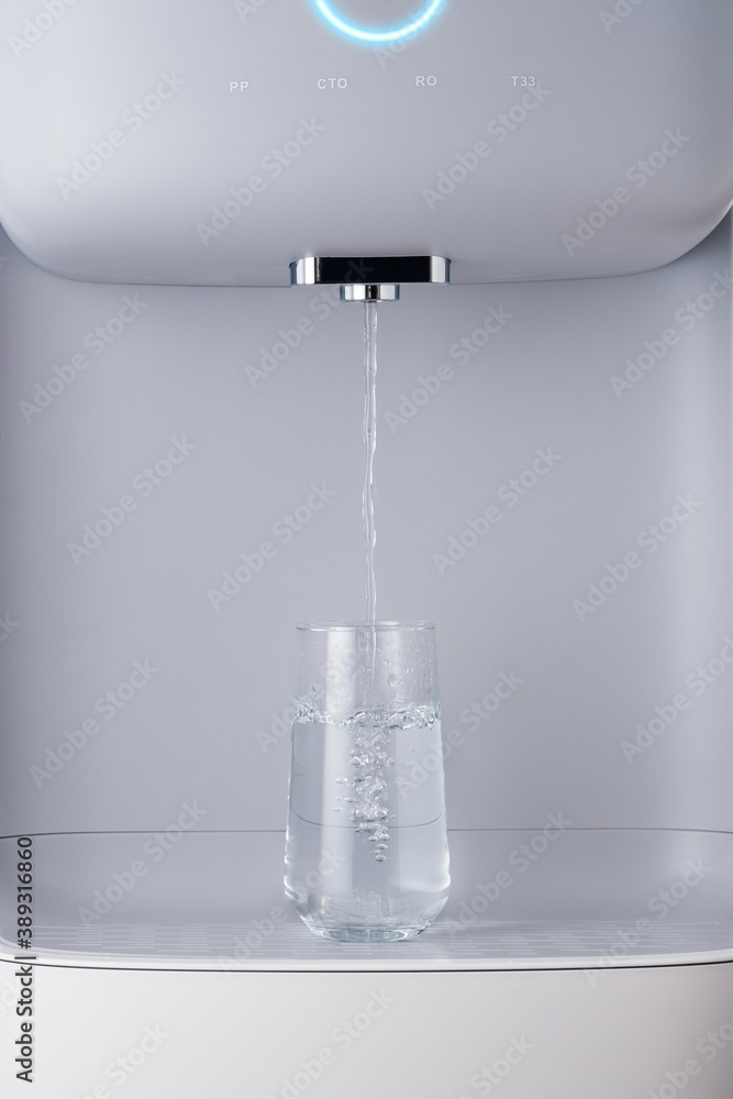 Modern technology concept. New water cooler format. A glass of pouring ...