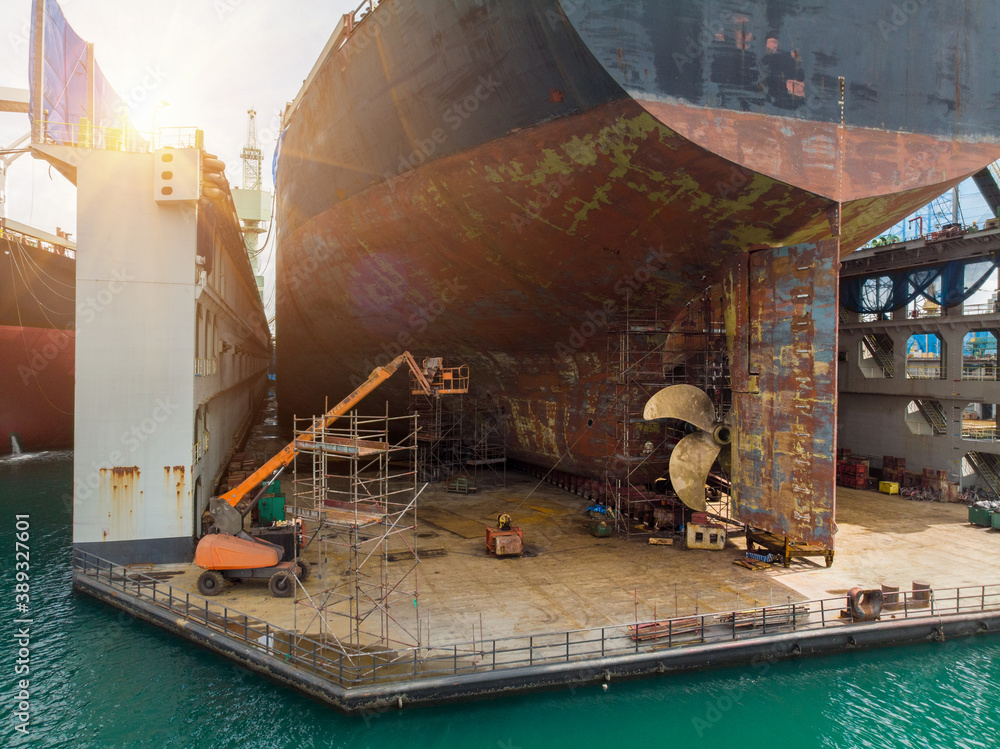 Cargo container ship stern with propeller at dry dock for maintenance ...