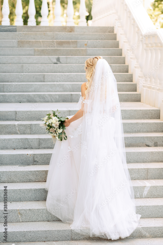 portrait of the bride with flowers in a beautiful wedding dress in full ...