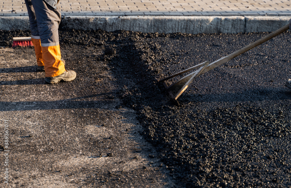 Freshly laid black bitumen asphalt with a high edge to the gravel ...