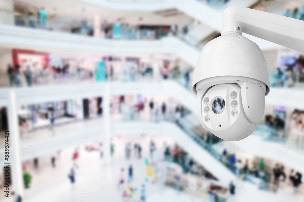 Modern public CCTV camera with blur interior shopping mall background ...