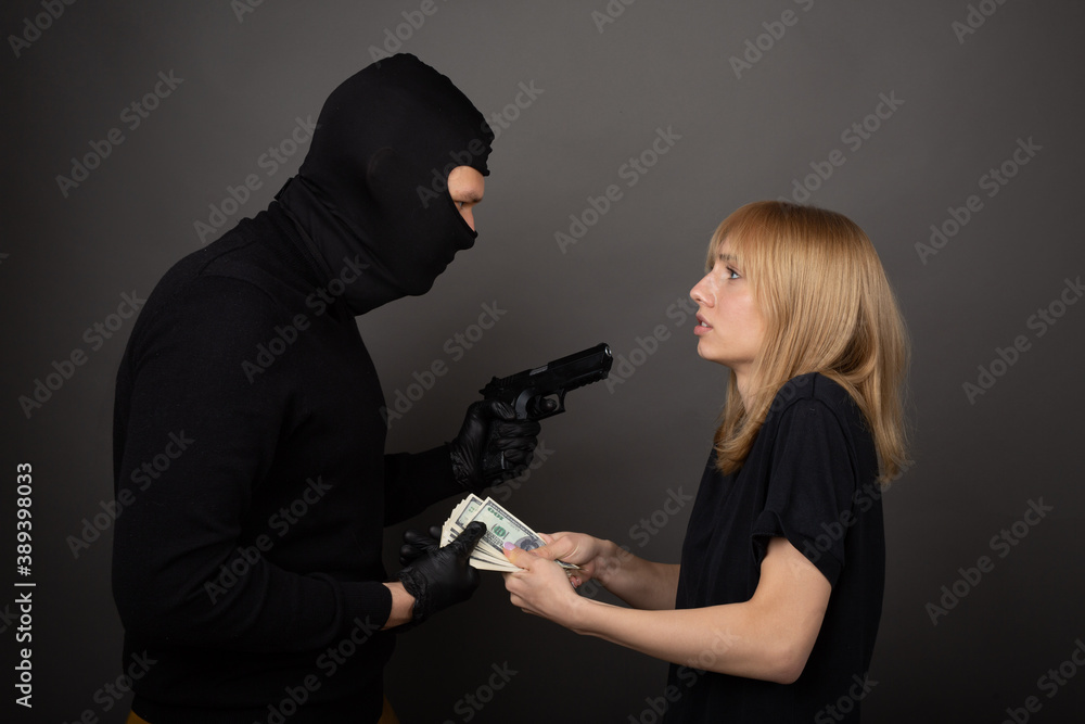robbery of a woman by a criminal with a gun Stock Photo | Adobe Stock