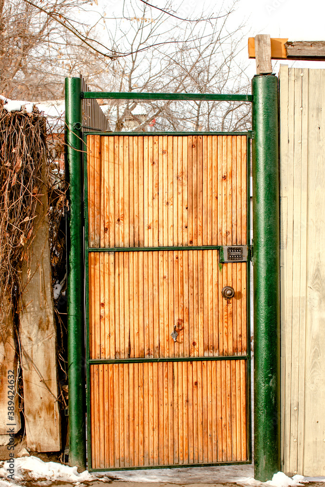 a large door a gate in the fence is made of a metal frame and wooden ...