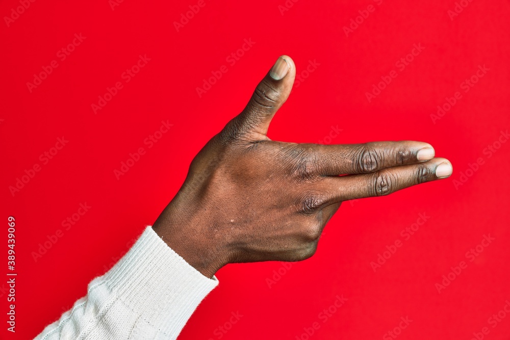 Arm and hand of african american black young man over red isolated ...