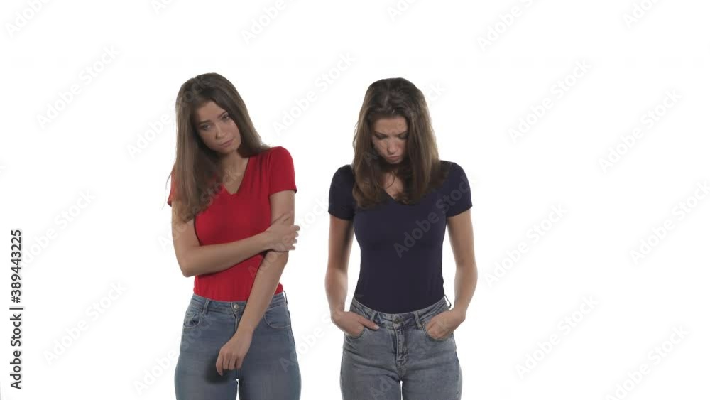 Caucasian twin sisters looking down with a guilty look. Body language ...