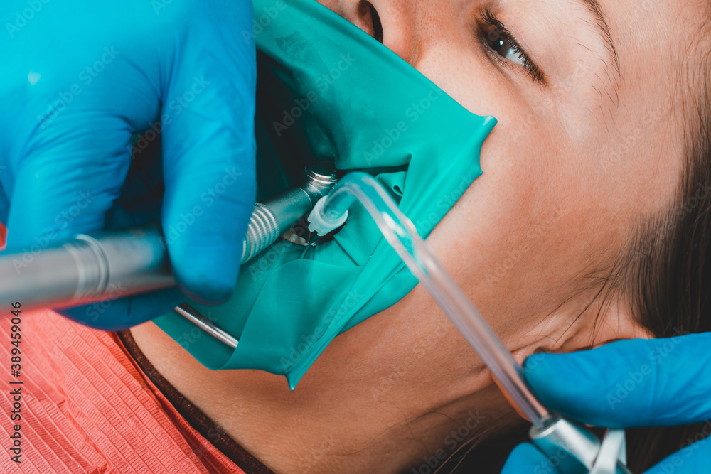 dentist treats the tooth with modern methods, uses a rubber dam ...