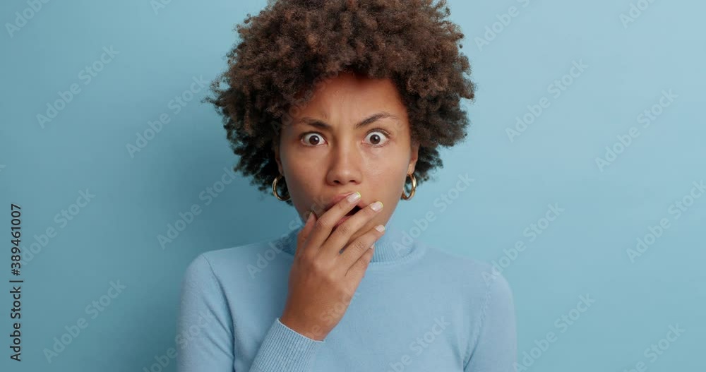 Astonished embarrassed dark skinned young woman stares in disbelief ...