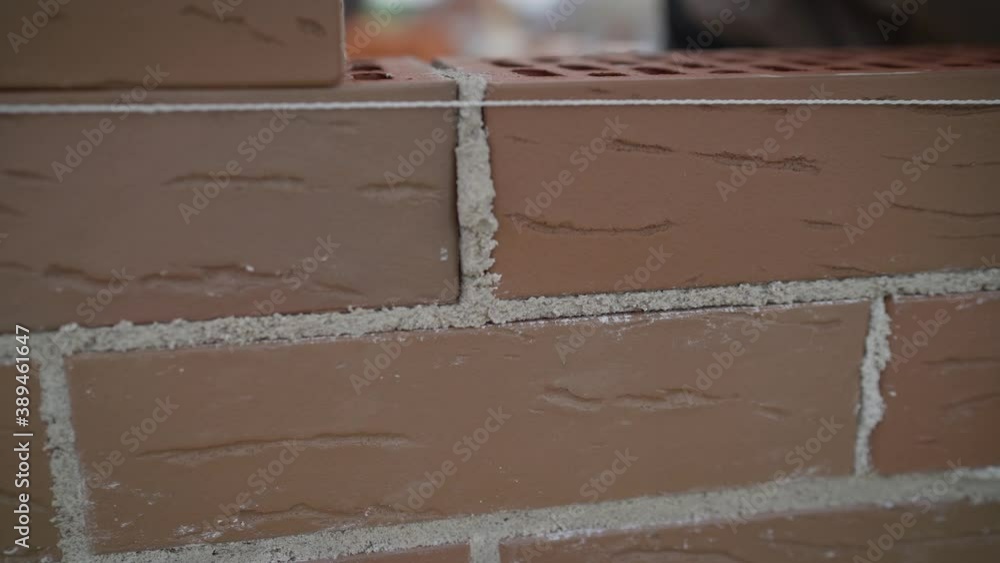 Stockvideo A worker rubbing seams on a brick wall while building a ...