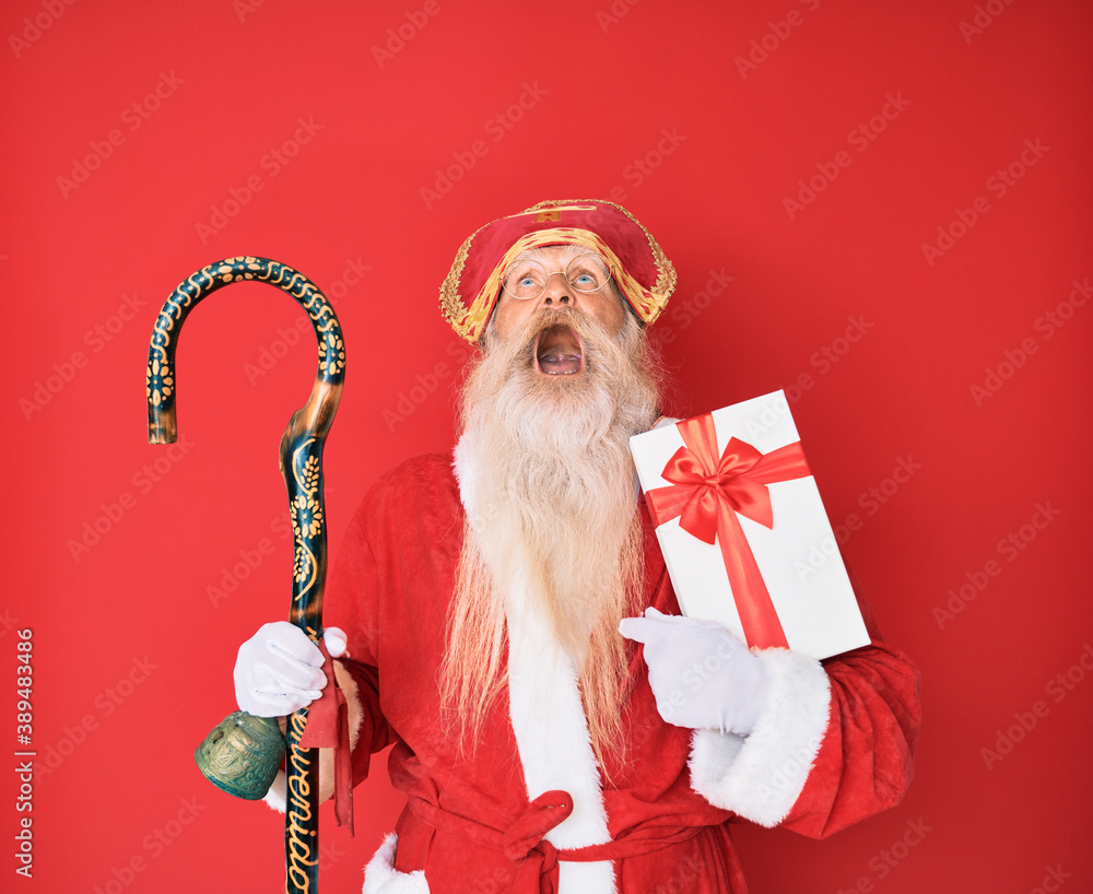 Old senior man with grey hair and long beard wearing saint nicholas ...