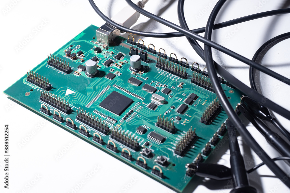 Wires are connected to the PCB. Concept - PCB testing. Circuit board on ...