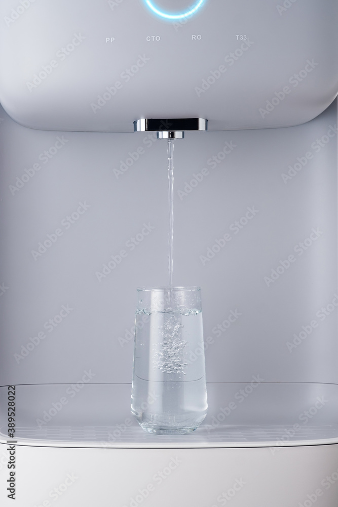 Modern technology concept. New water cooler format. A glass of pouring ...