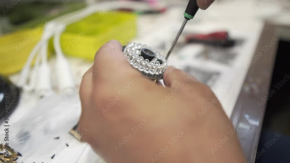 Engineer Assembles a CCTV camera by screwing the parts with a plug ...