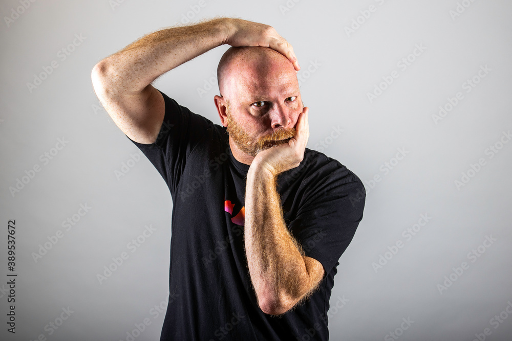 Foto de Bald man with beard cracking his neck by twisting it with his ...