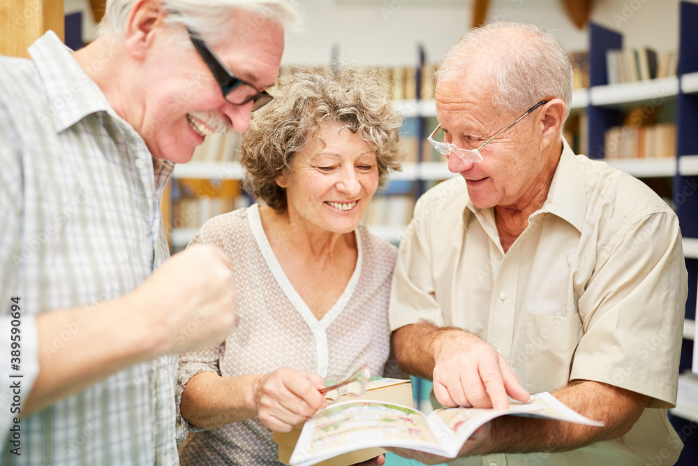 Seniors in the library with a book Stock Photo | Adobe Stock