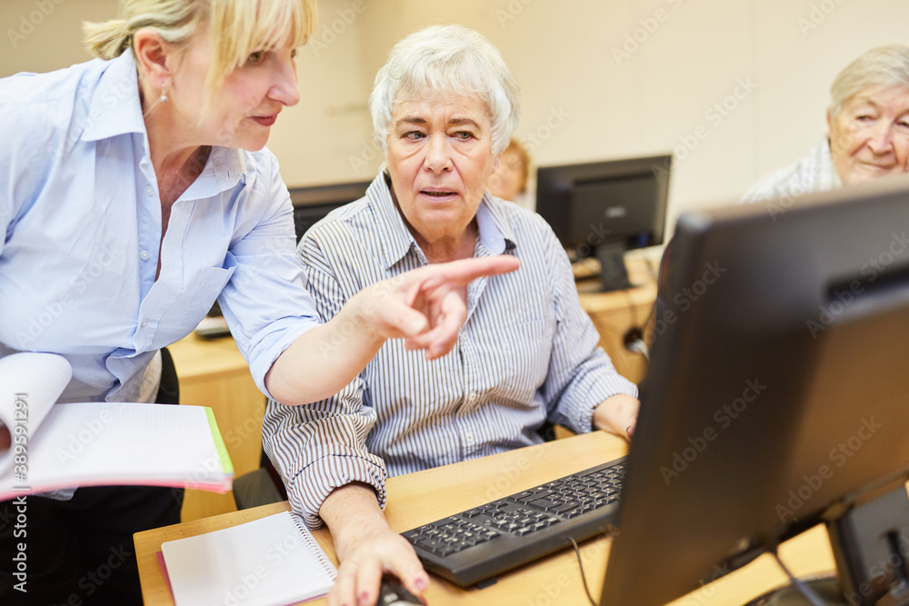 Lecturer helps seniors use the Internet Stock Photo | Adobe Stock
