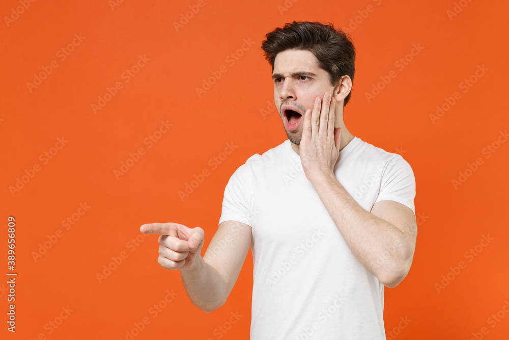 Shocked young man 20s wearing basic empty blank white t-shirt standing ...