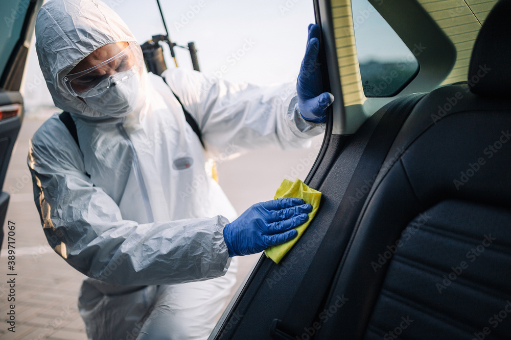 Sanitizing service worker cleans the car's interior with a yellow rug ...