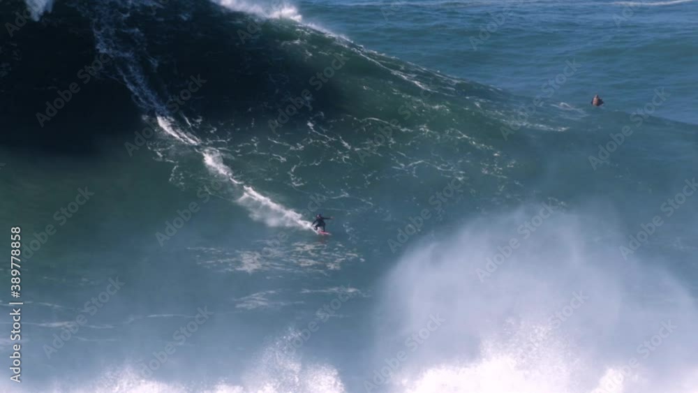 Slow motion of a big wave surfer riding one of the biggest waves of the ...