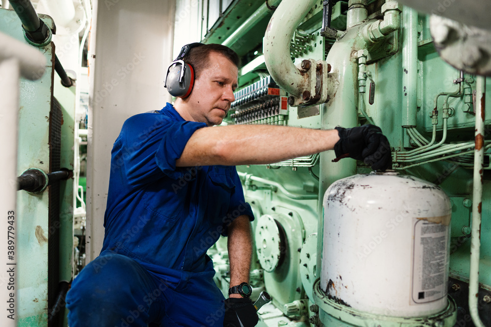Marine engineer officer controlling vessel engines and propulsion in ...