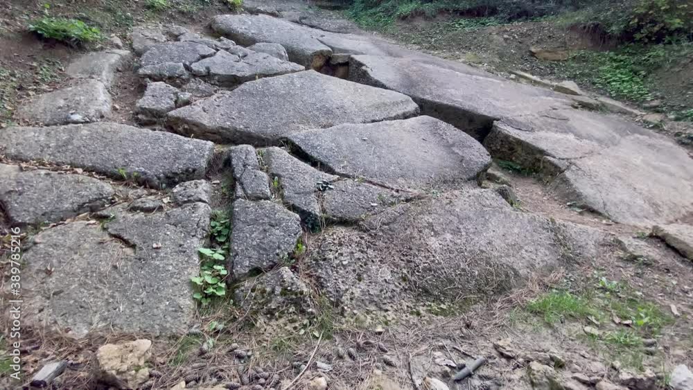 Dolly move shows stones and concrete of excavations at the pyramid of ...