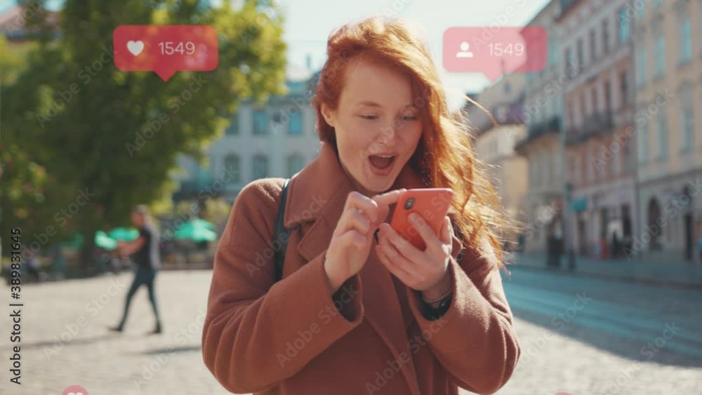 Vidéo Stock Young surprised ginger woman with smartphone in hands. Cute ...