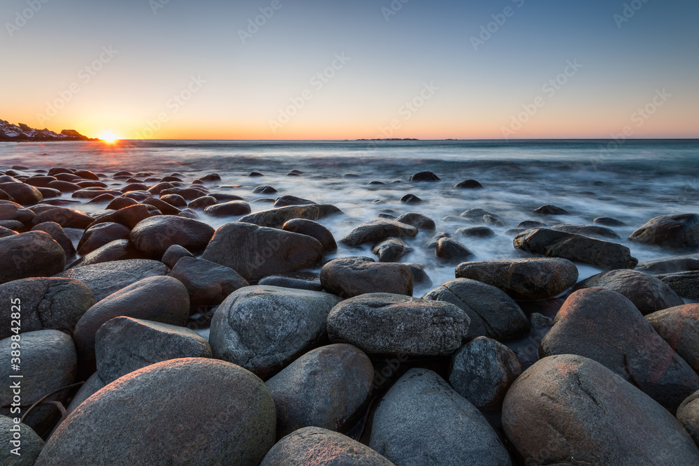 The famous beach near Uttakleiv with round shaped rock boulders on the ...