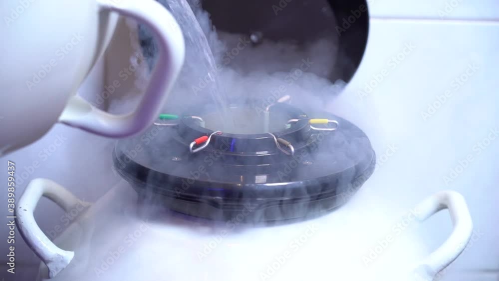 Scientist opens a Cryogenic container with medical samples and pour ...