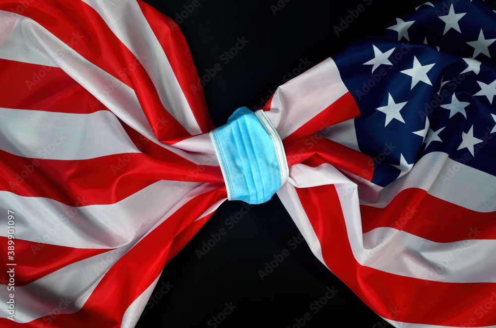 Flag of USA tied with a face protection mask. COVID - 19 problems in ...