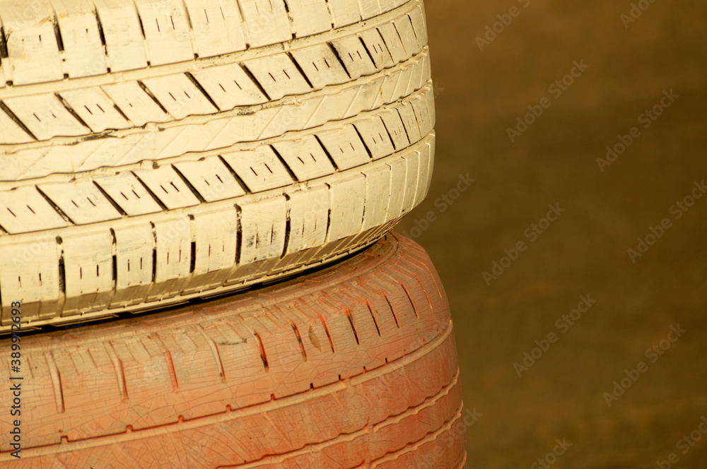 Painted tires close up. Two rubber tires, painted white and red, are ...